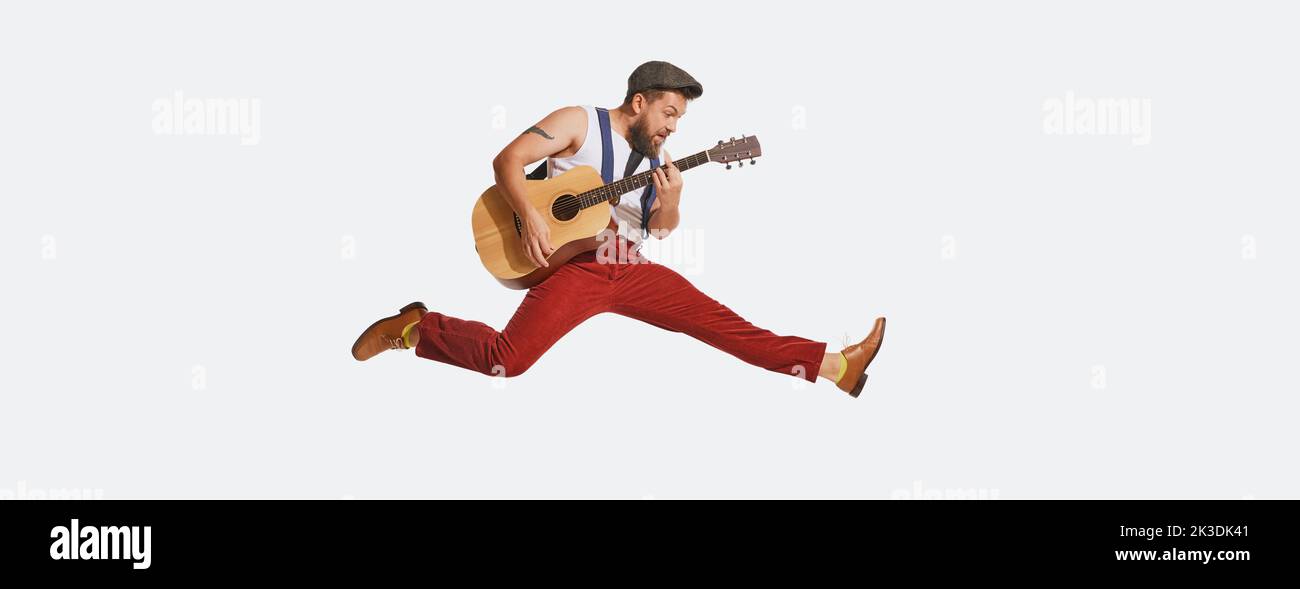 Expressive musician wearing retro style clothes playing guitar like ...