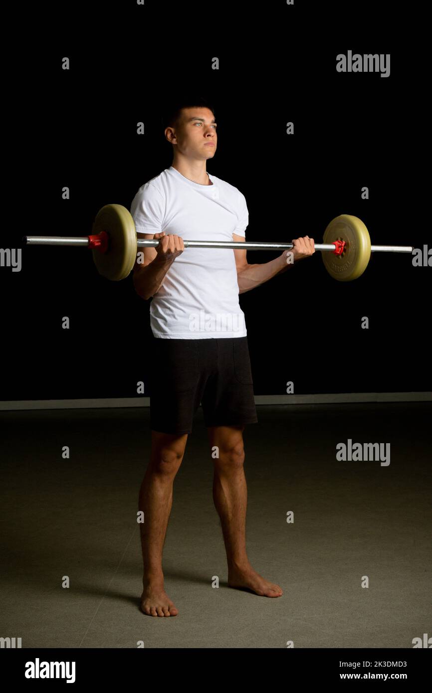 19 year old teenage boy excercising his biceps with a barbell Stock ...