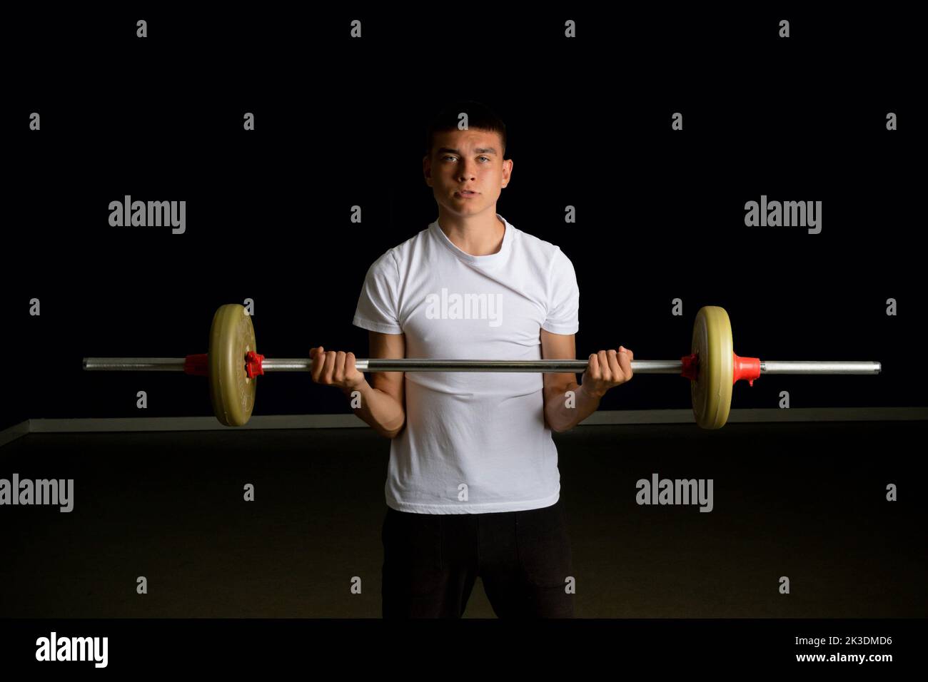 19 year old teenage boy excercising his biceps with a barbell Stock ...