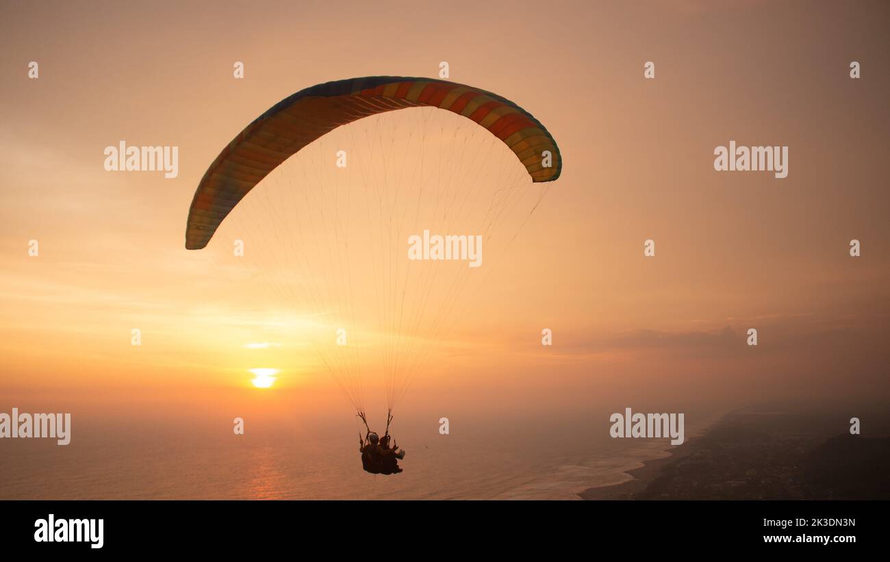 Panorama view of a tandem paragliding closeup over the ocean and beach ...