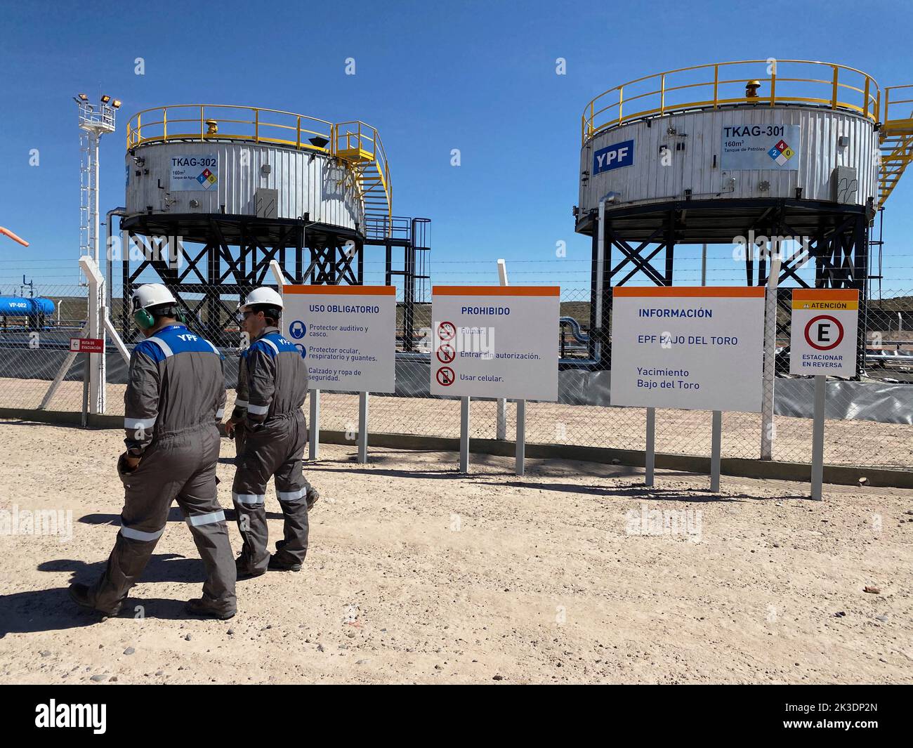 Ypf personnel walk past oil water storage tanks onshore unconven hi-res ...