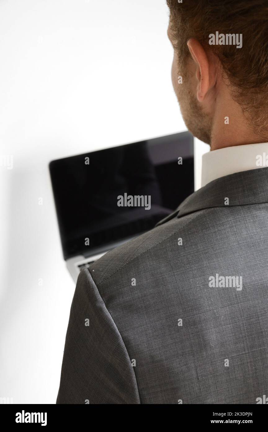 Businessman behind a laptop computer against white background Stock ...