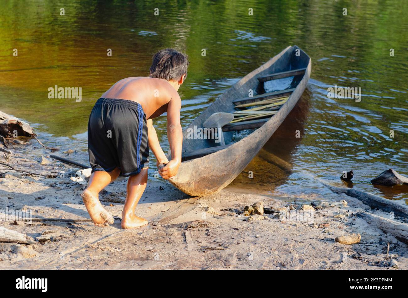 Colombia, Piaraparana, Tukano indian pushes canoe out Stock Photo - Alamy