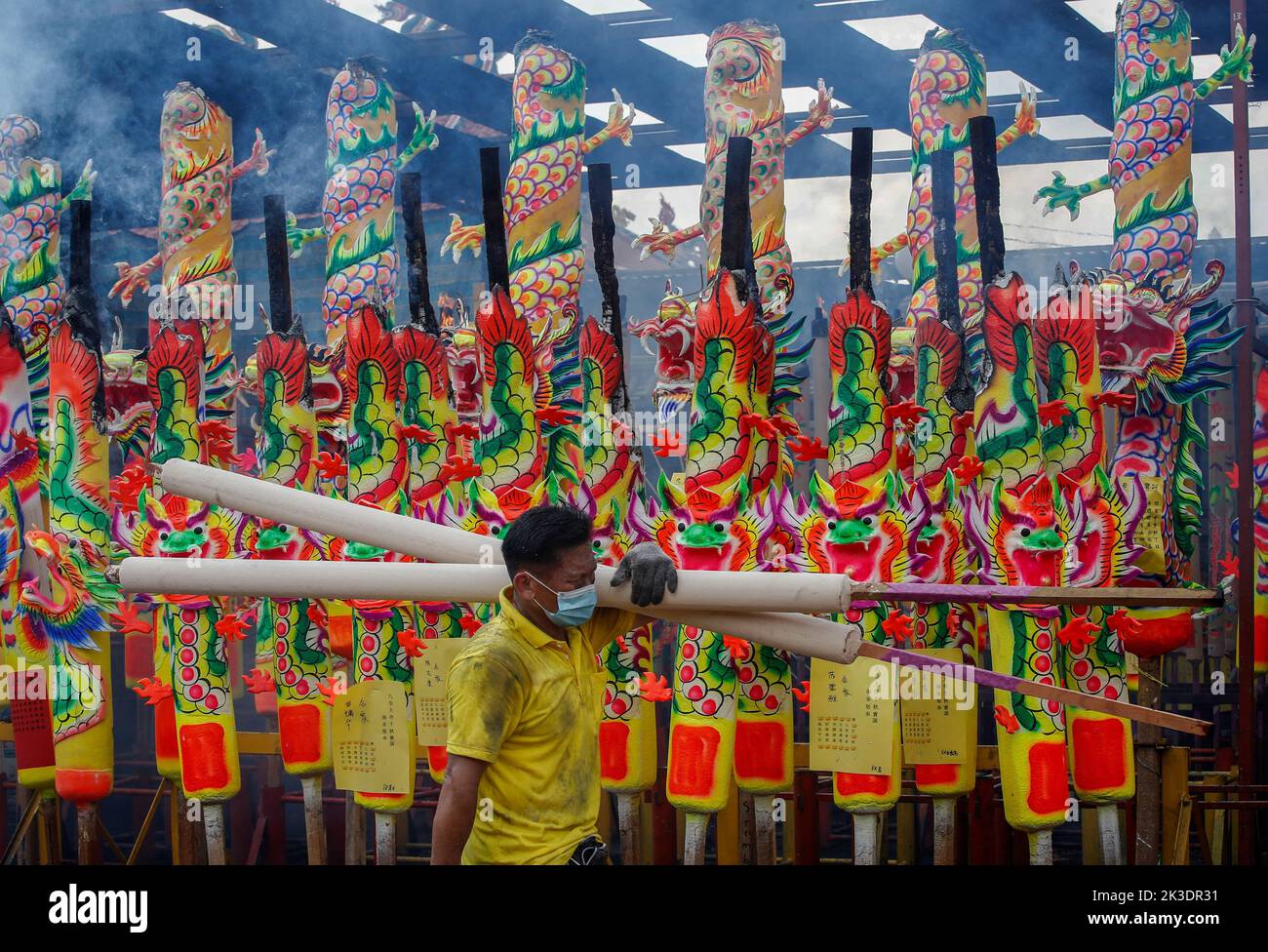 A temple worker seen carrying the giant incense sticks during the ...