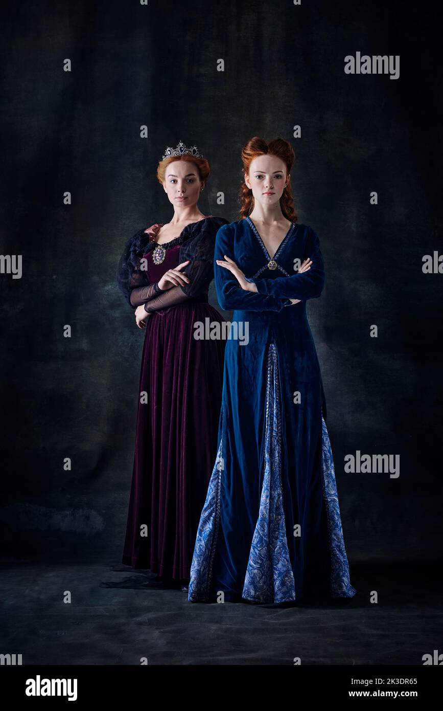 Portrait of two beautiful women in image of queen and princess isolated ...