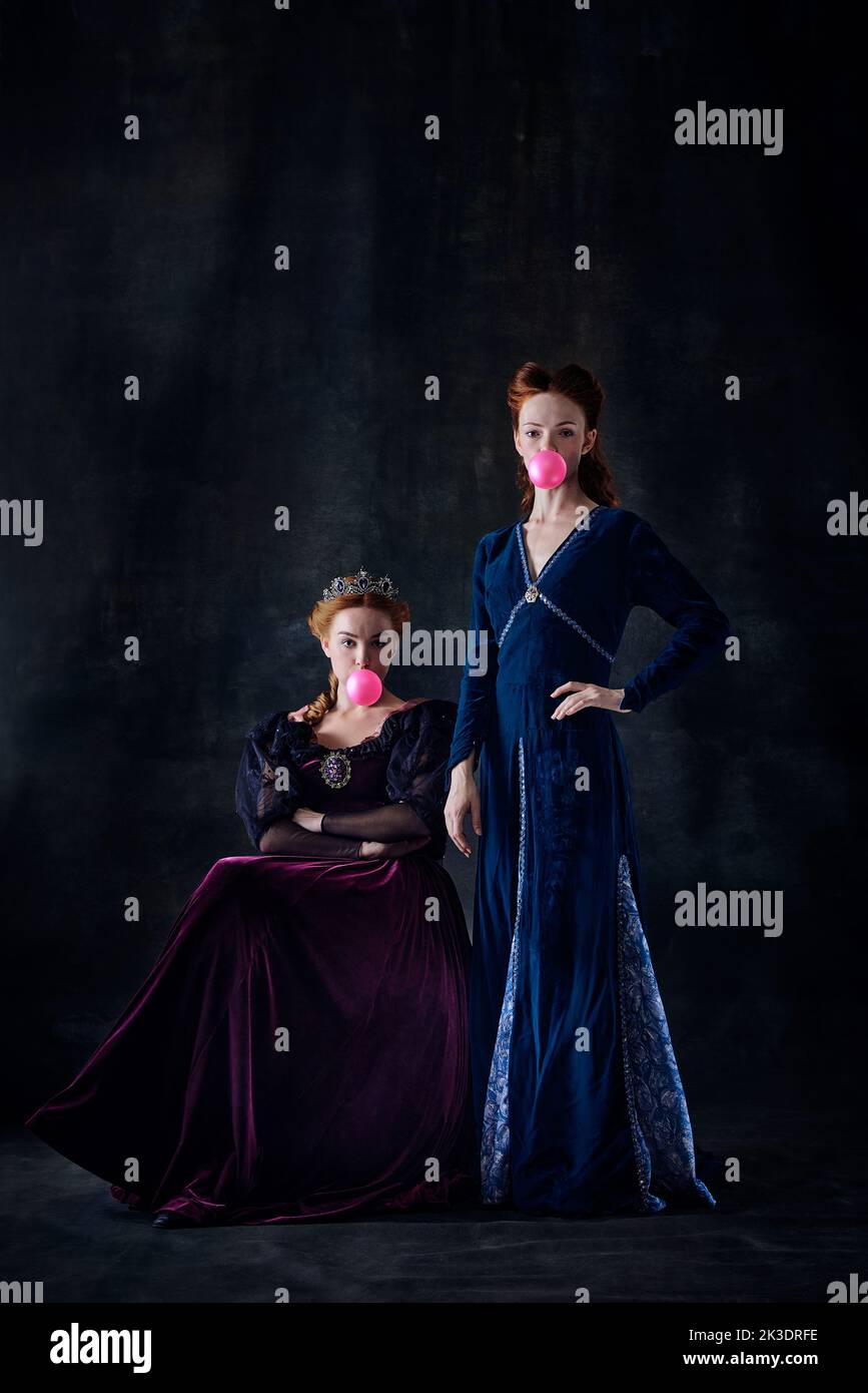 Portrait of two beautiful women in image of queen and princess posing ...