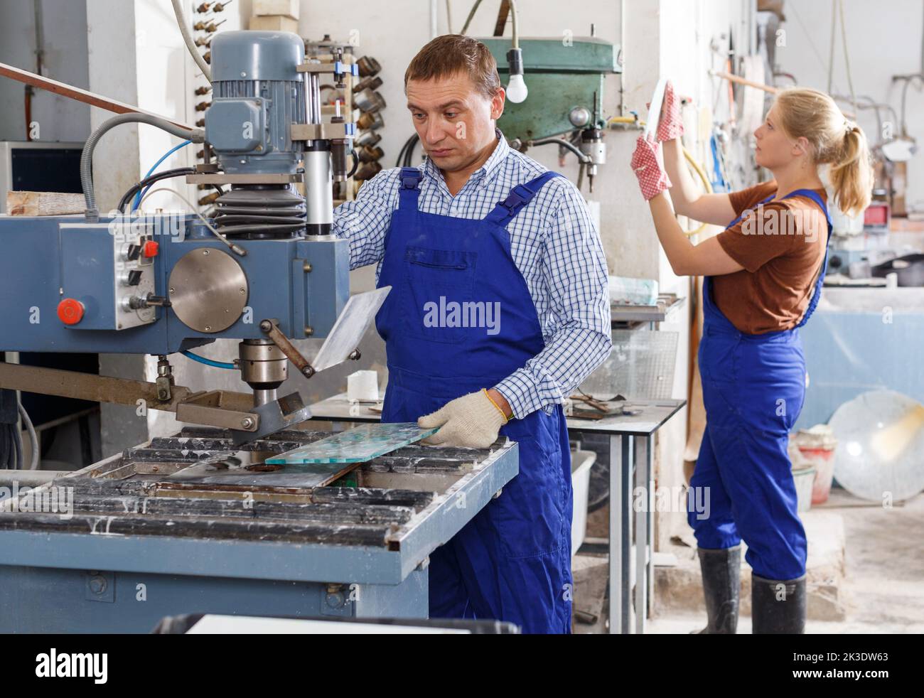 Craftsman working on glass drilling machine Stock Photo - Alamy