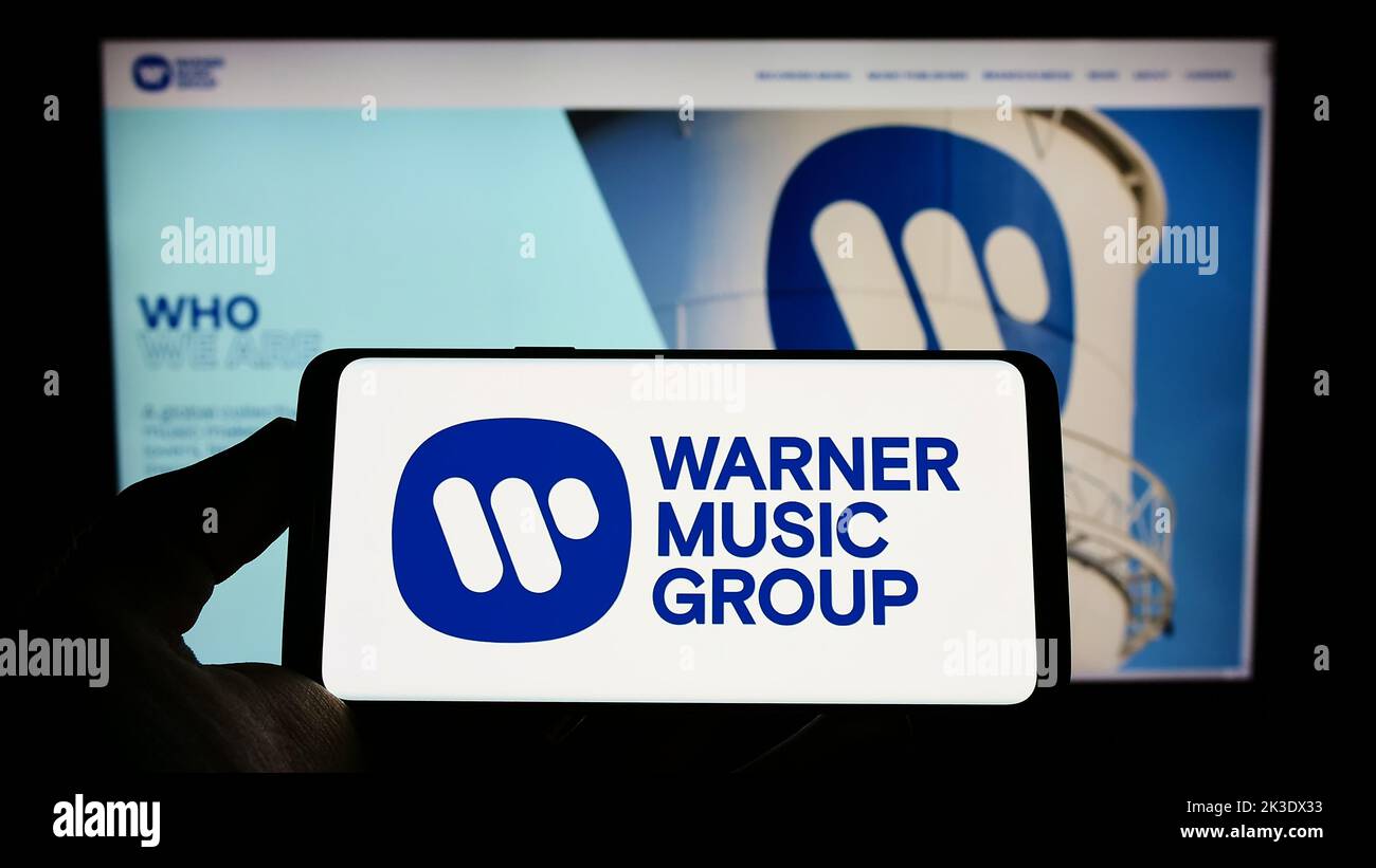 Person holding smartphone with logo of entertainment company Warner ...