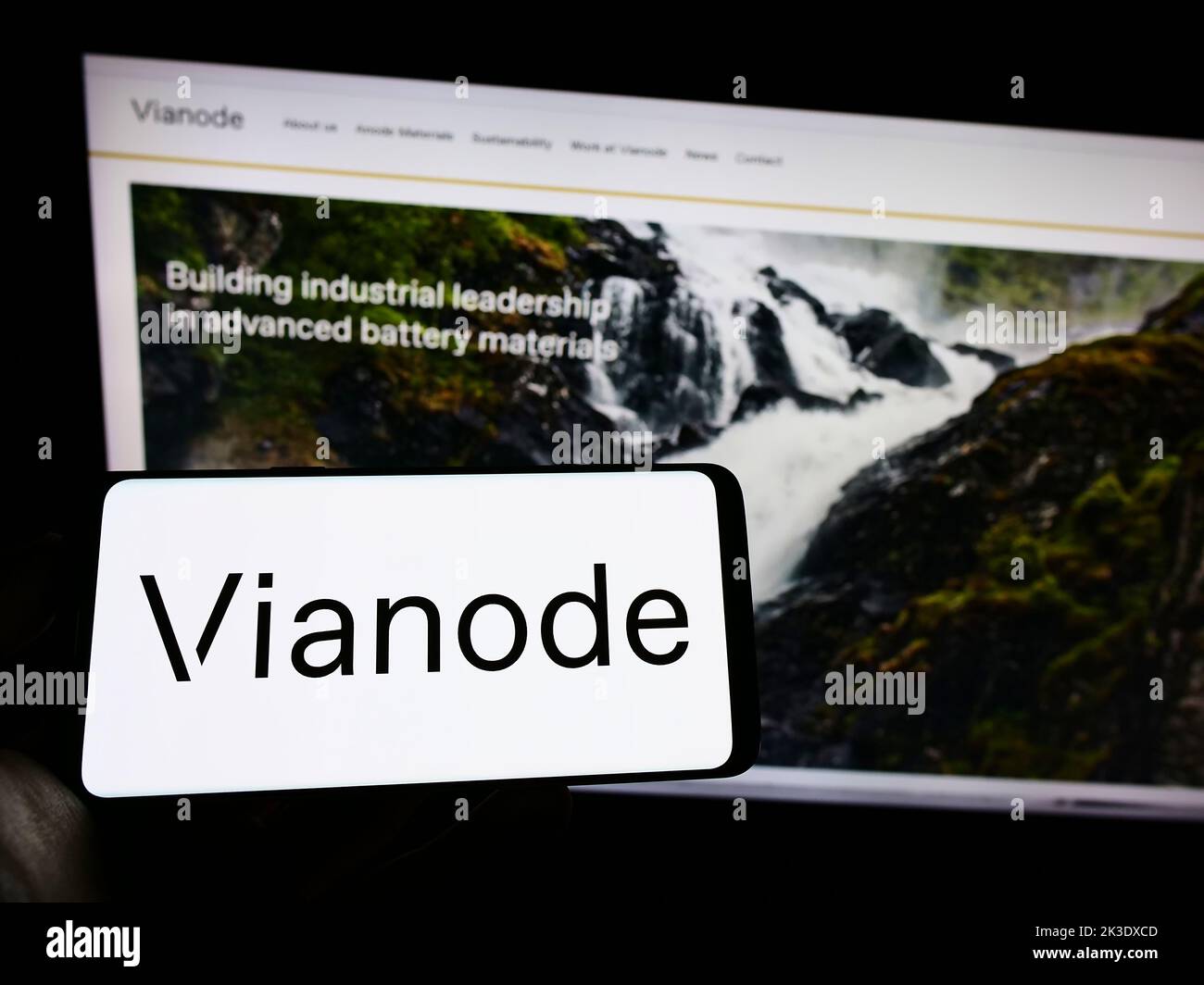 Person holding cellphone with logo of Norwegian battery materials company Vianode on screen in ...