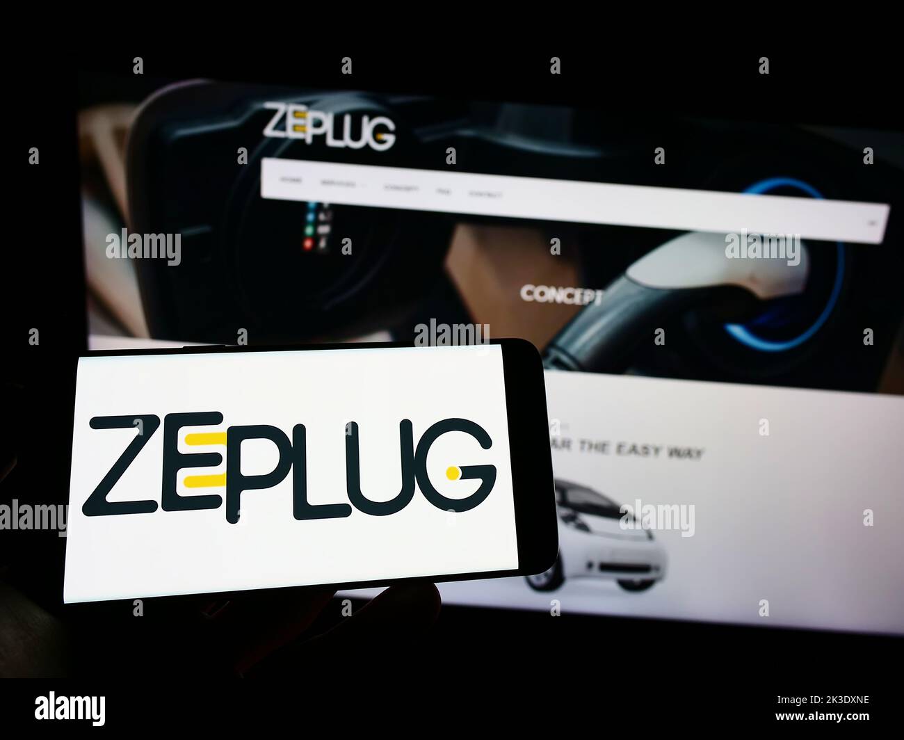 Person holding mobile phone with logo of French EV charging company ...