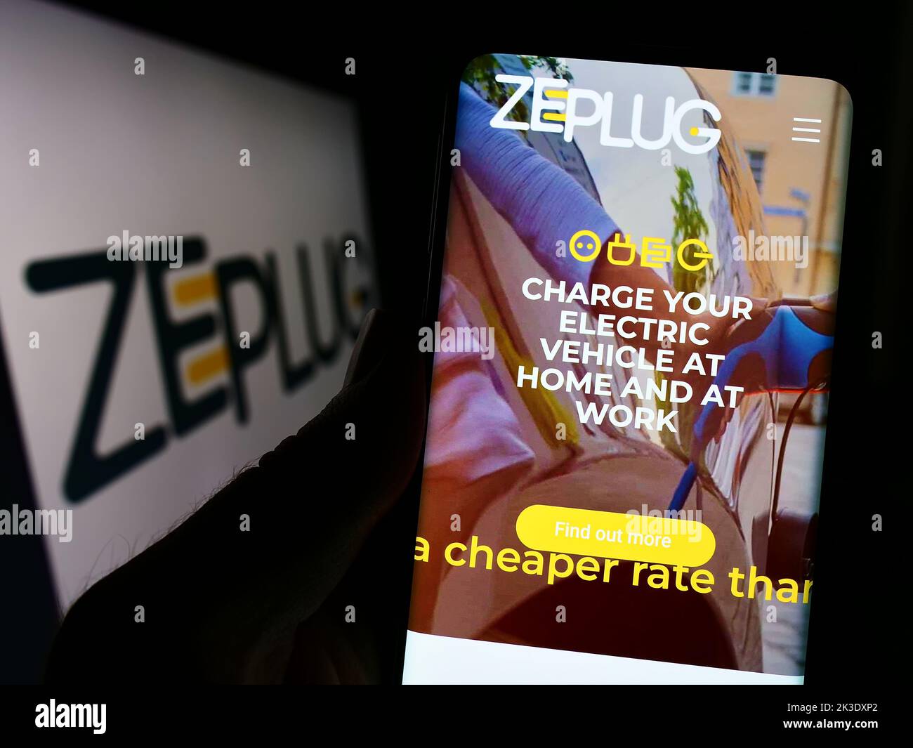 Person holding cellphone with webpage of French EV charging company ...