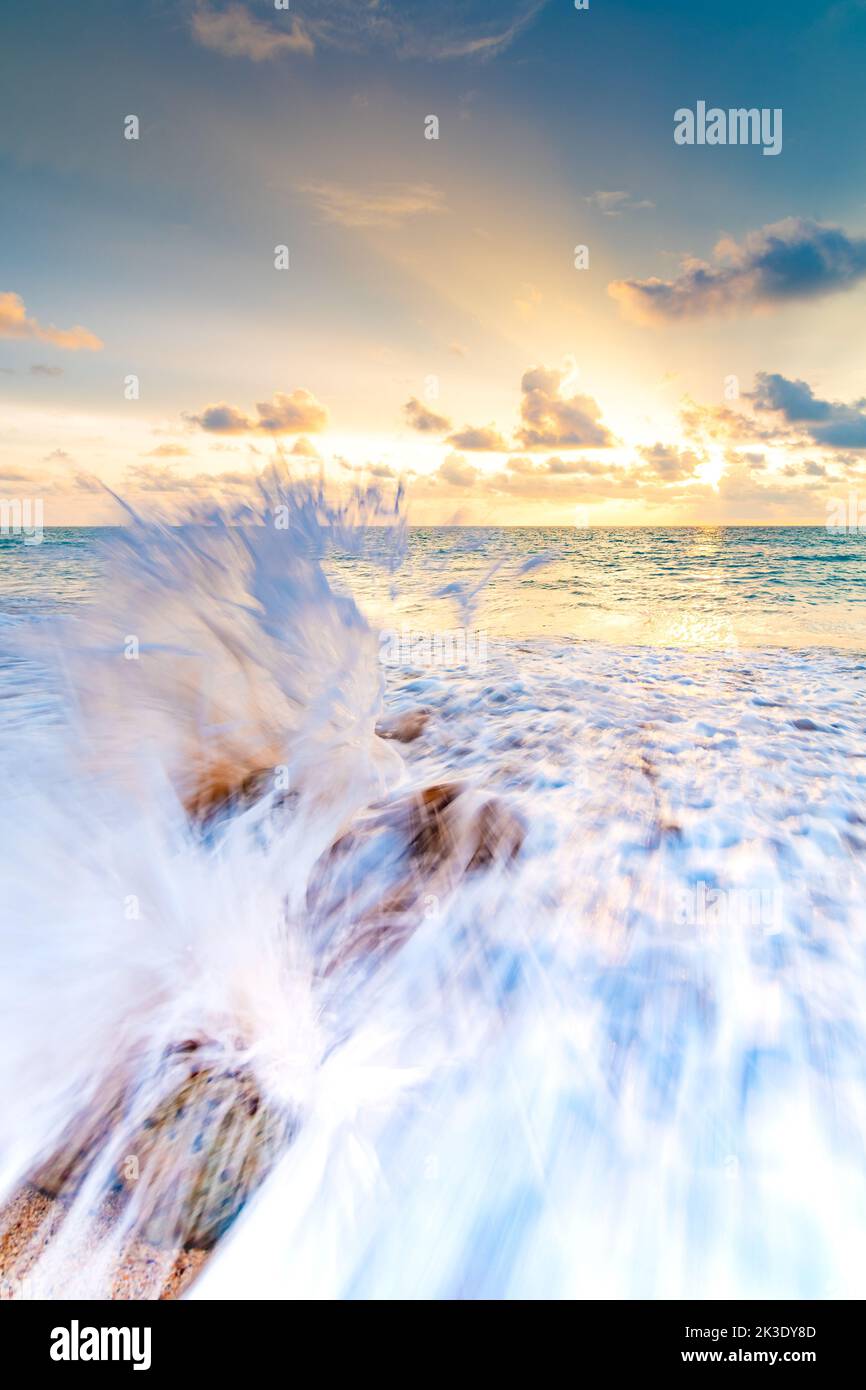 Detail view of rock on the beach, placed in the sand, with big water ...