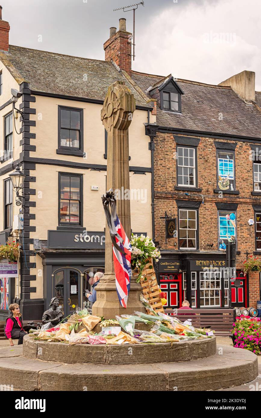A stone monument set in a market place. The circular base is covered ...