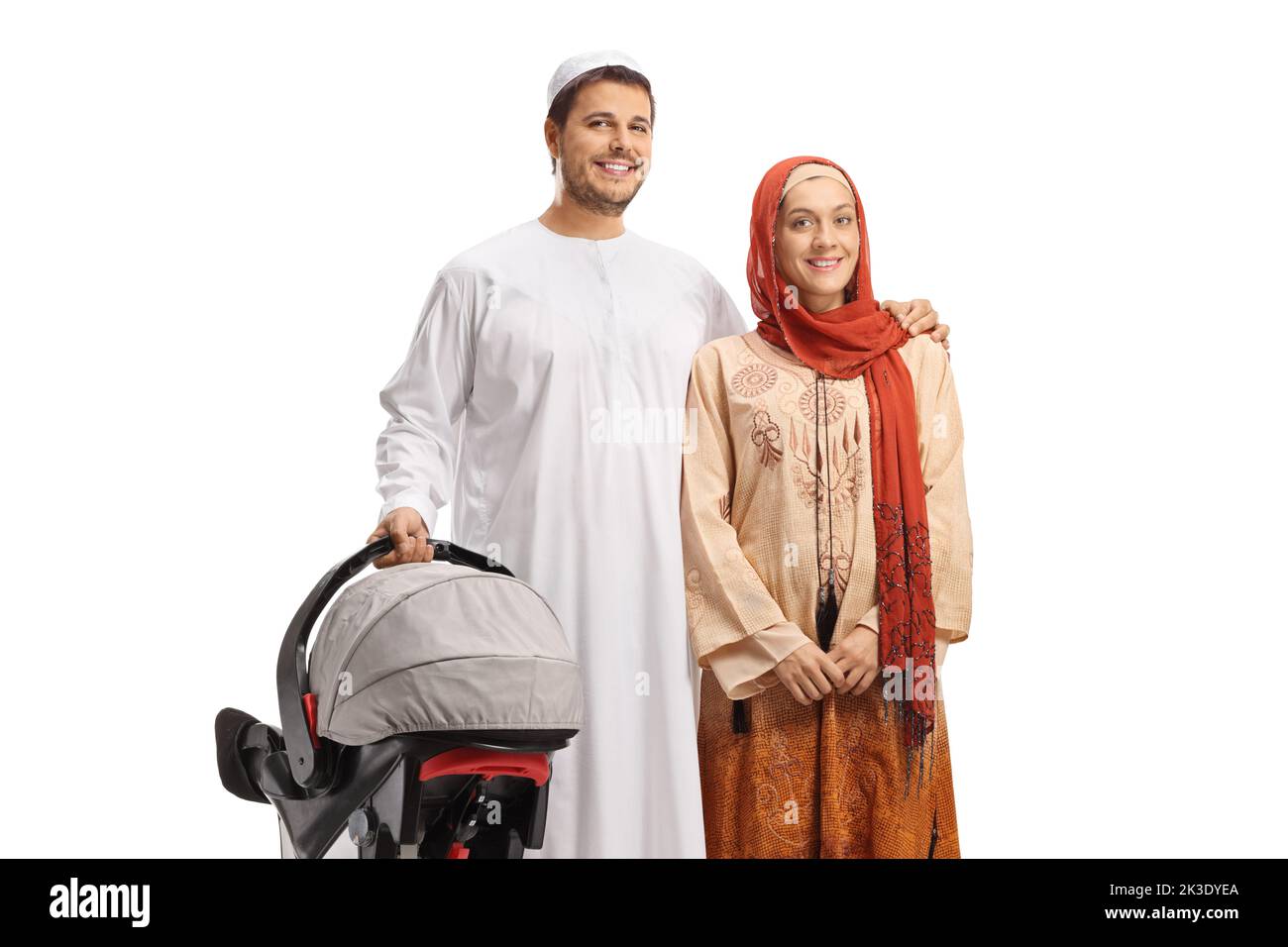 Husband and wife in ethnic clothes holding a baby transporting carrier ...