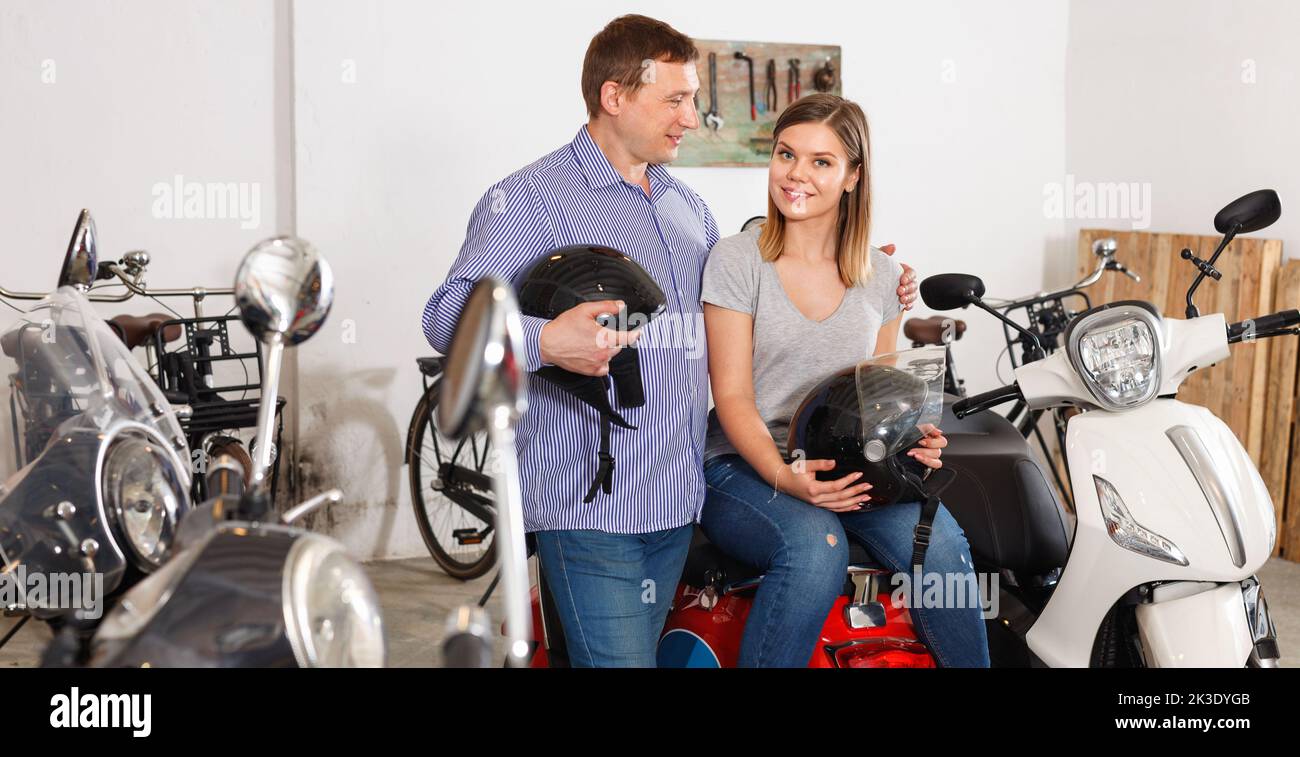 Portrait of male with female who are satisfied of shopping in moto ...