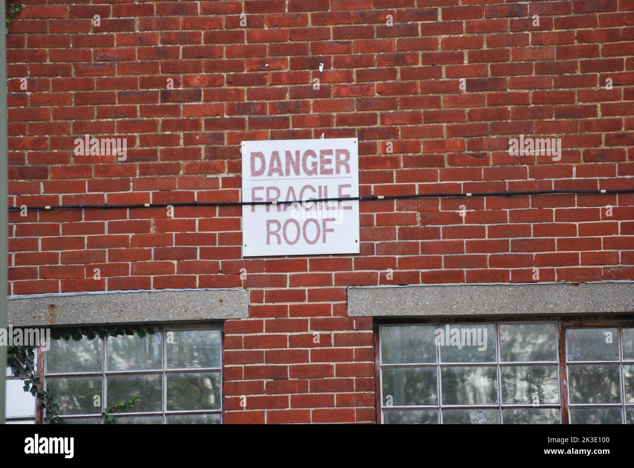 Danger fragile roof sign on the brick wall / building Stock Photo - Alamy