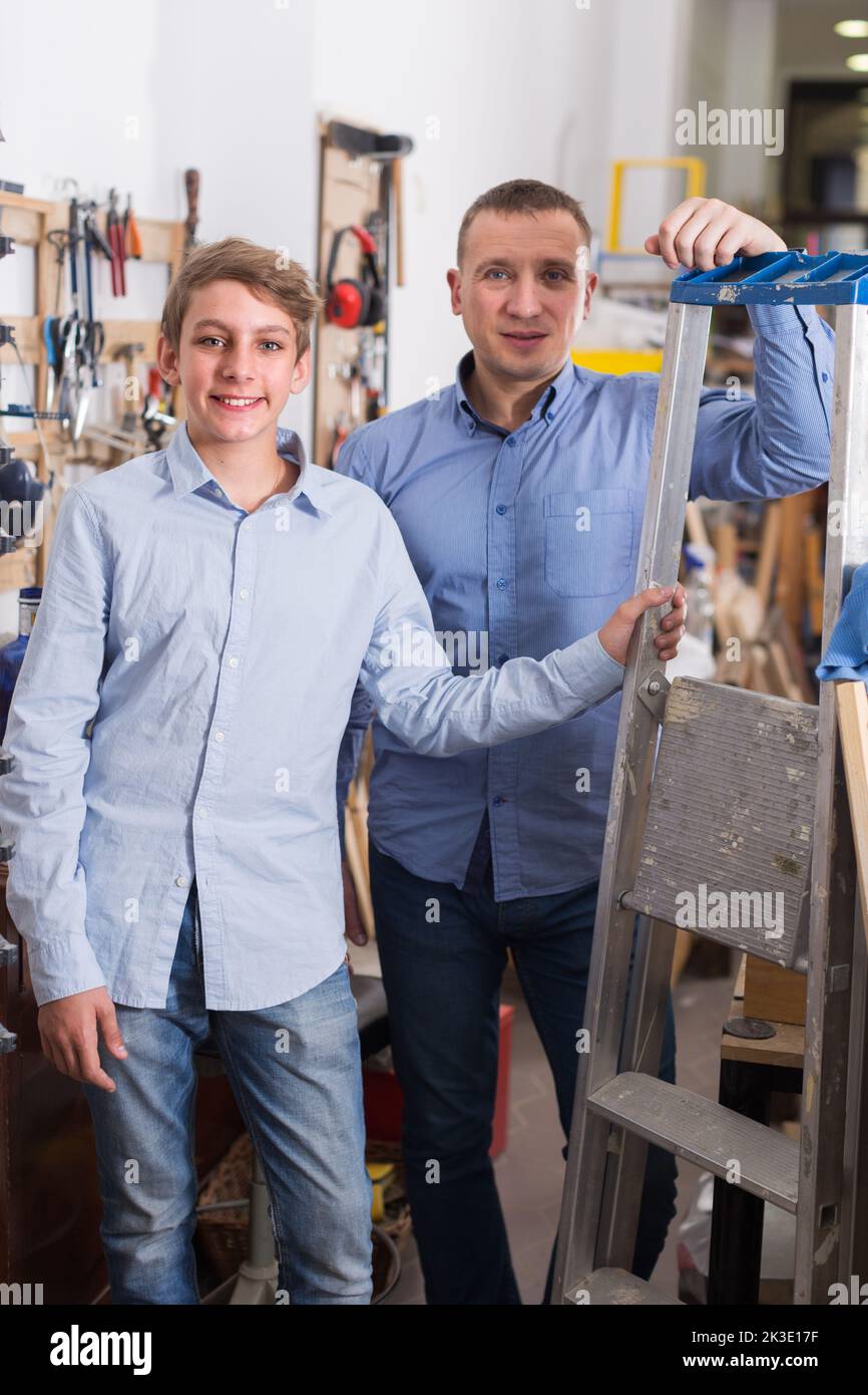 Portrait of male handsome guy and boy with ladder in workplace Stock ...