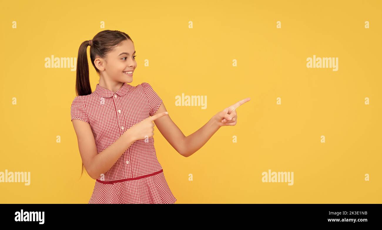 happy kid pointing finger on yellow background copy space, announcement ...