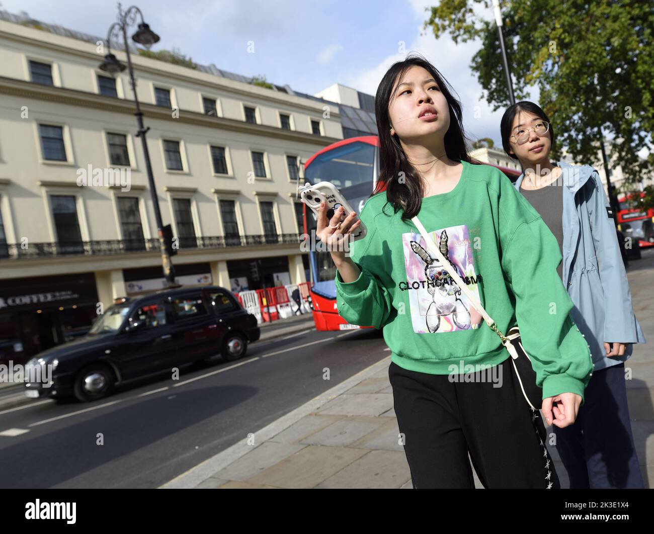 London, England, UK. Young Asian woman with a mobile phone in the ...