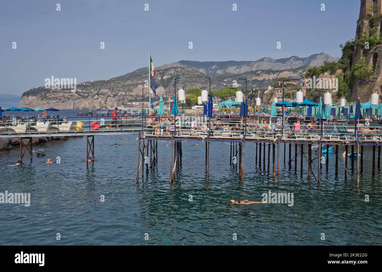 Tourists swimming and sunbathing at a private lido beach resort in the ...