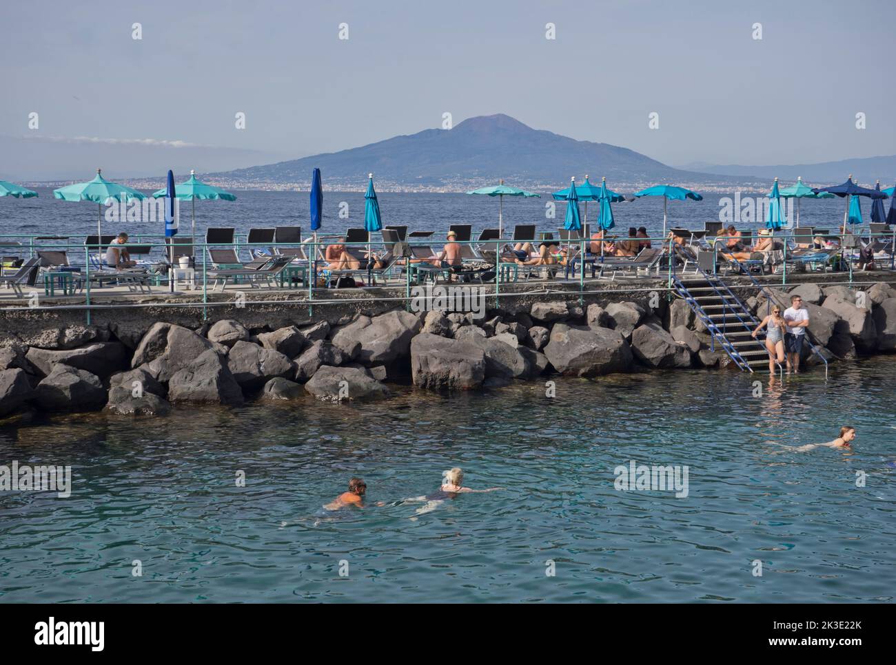 Tourists swimming and sunbathing at a private lido beach resort in the ...
