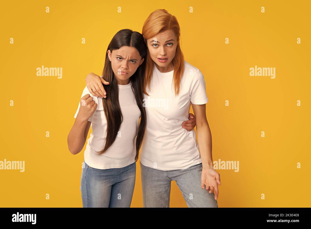 Woman with child teen girl. Mommy and daughter isolated on yellow ...