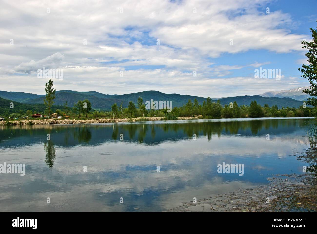 Summer landscape with lake, mountains, blue sky and clouds, in Gorj ...