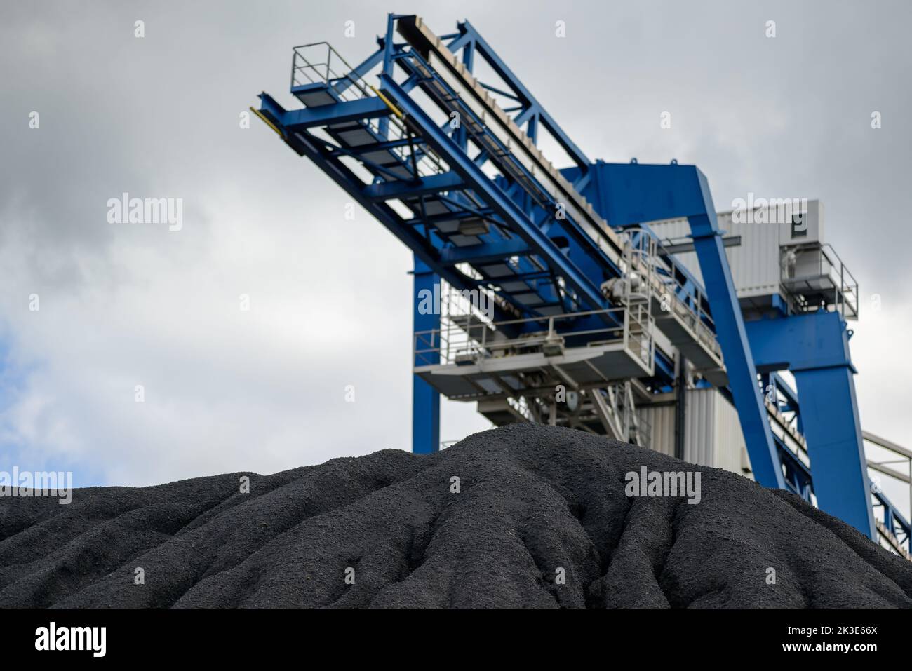 Huge mountain of black coal and a steel structure for transporting coal ...