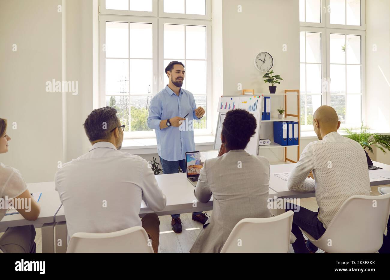 Team of employees sitting at office table during meeting with ...
