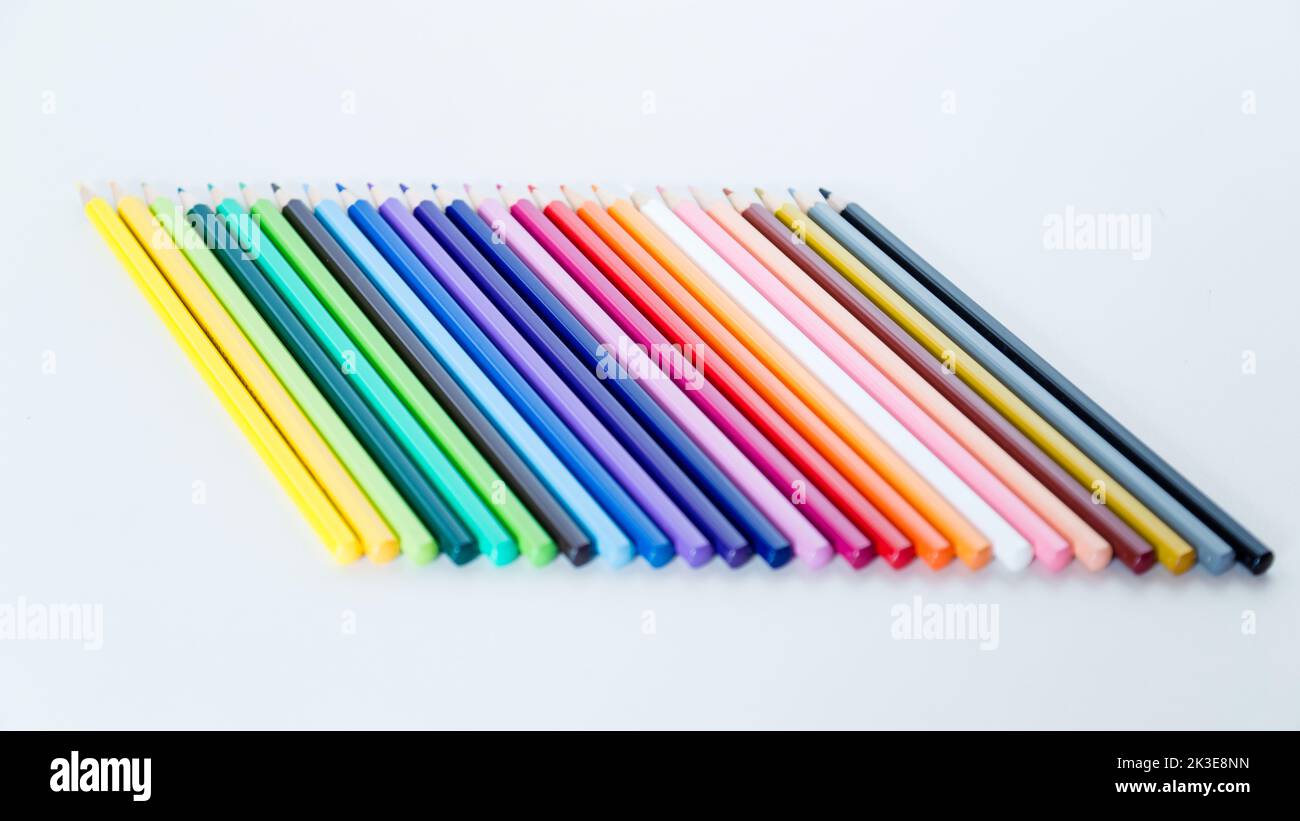 Colored pencil crayons in a row on white background Stock Photo - Alamy