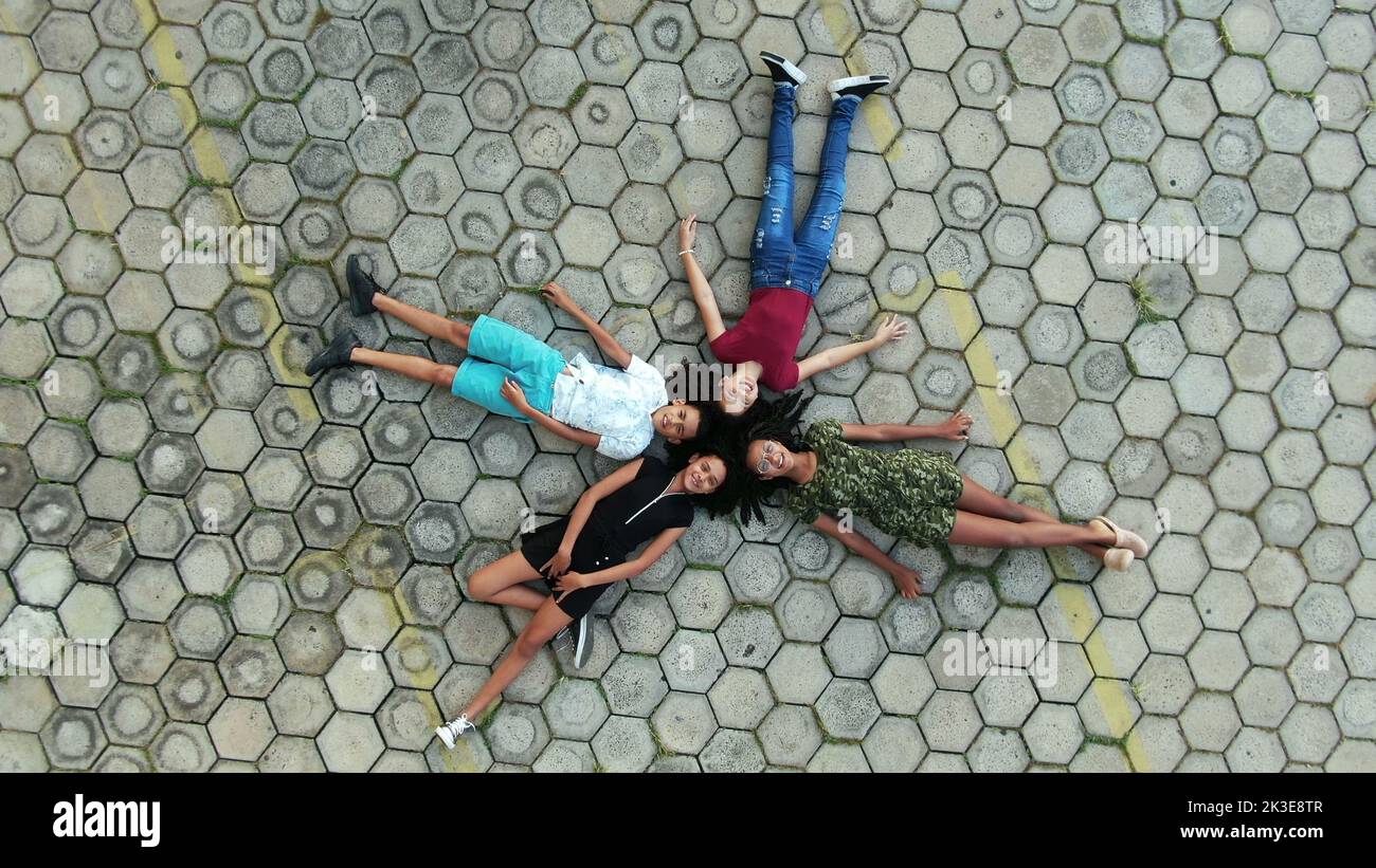 Children laid on ground looking up at sky together. Kids seen from ...