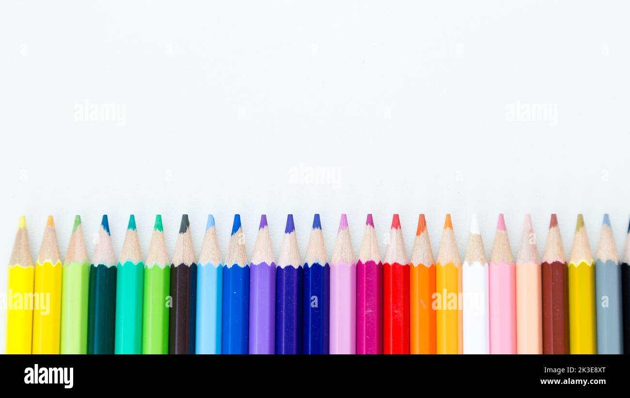 Colored pencil crayons in a row on white background Stock Photo - Alamy