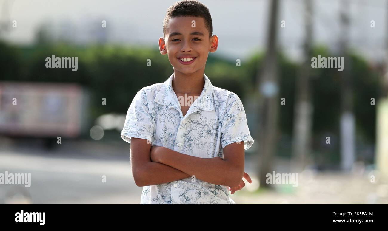 Brazilian child smiling at camera outside in street. Hispanic south ...