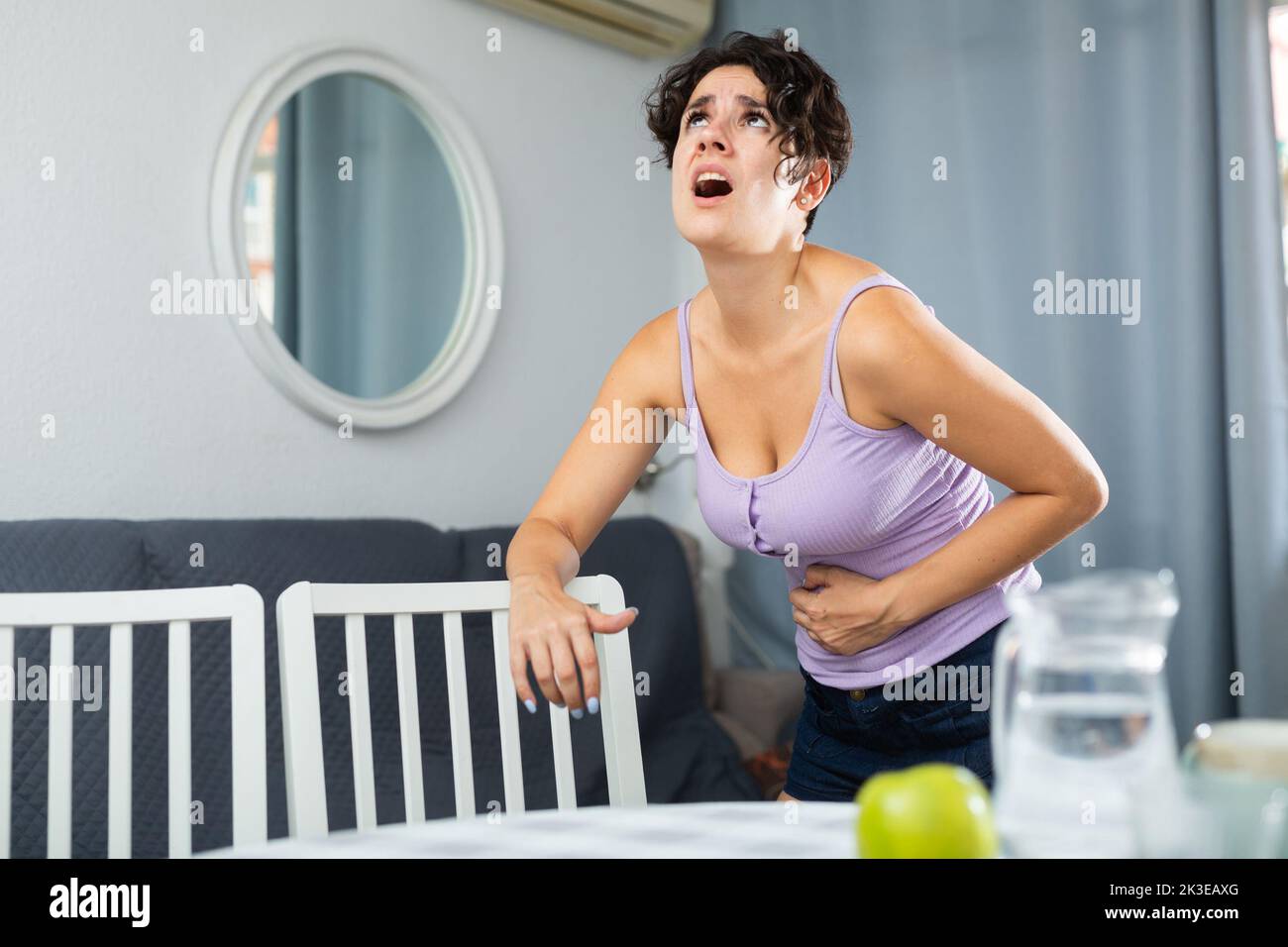 Sadness woman suffering from stomach pain at home Stock Photo - Alamy