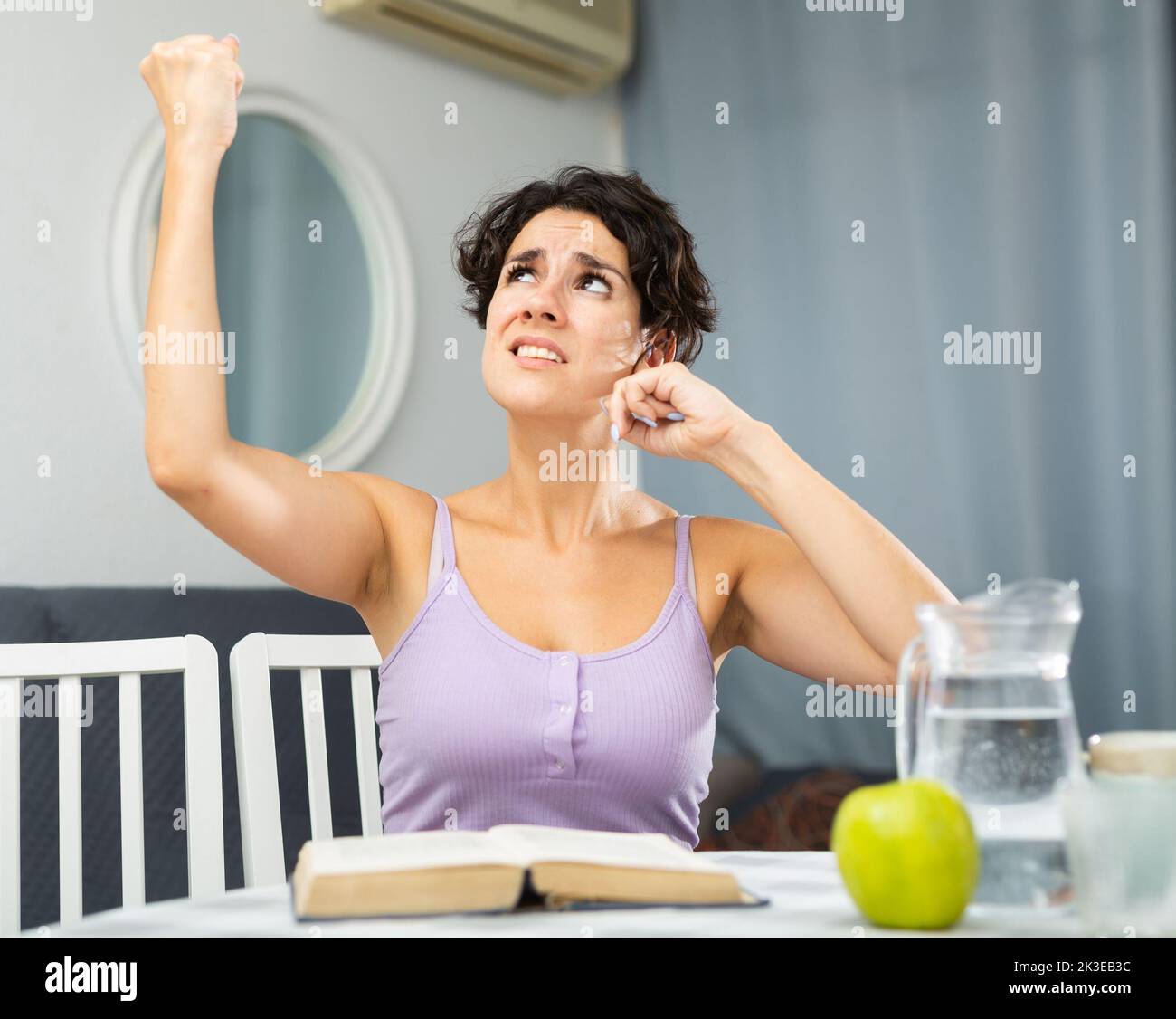 Displeased stressed woman suffering from noisy neighbors from above ...