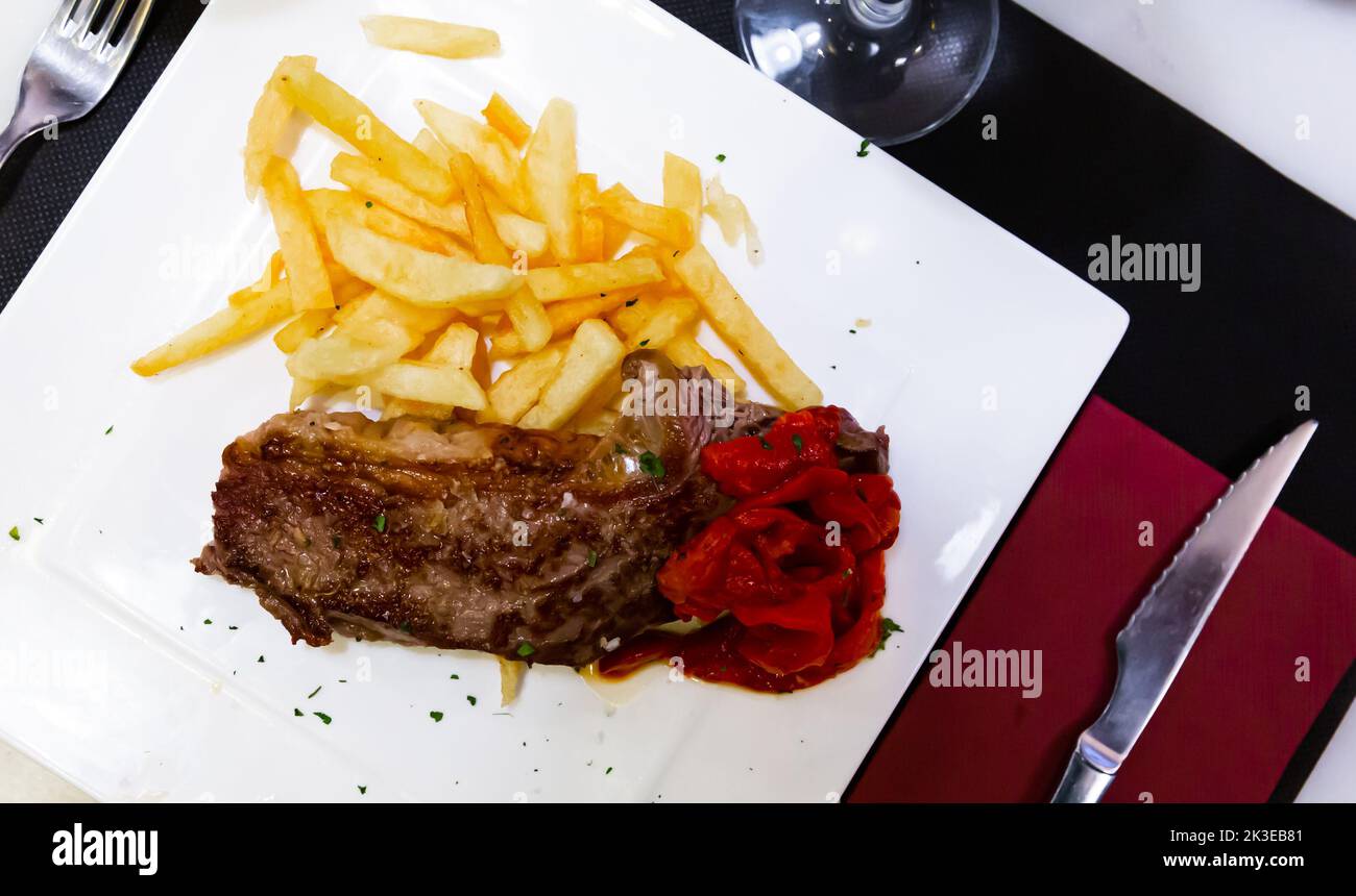 Veal entrecote with baked red pepper and fries Stock Photo - Alamy