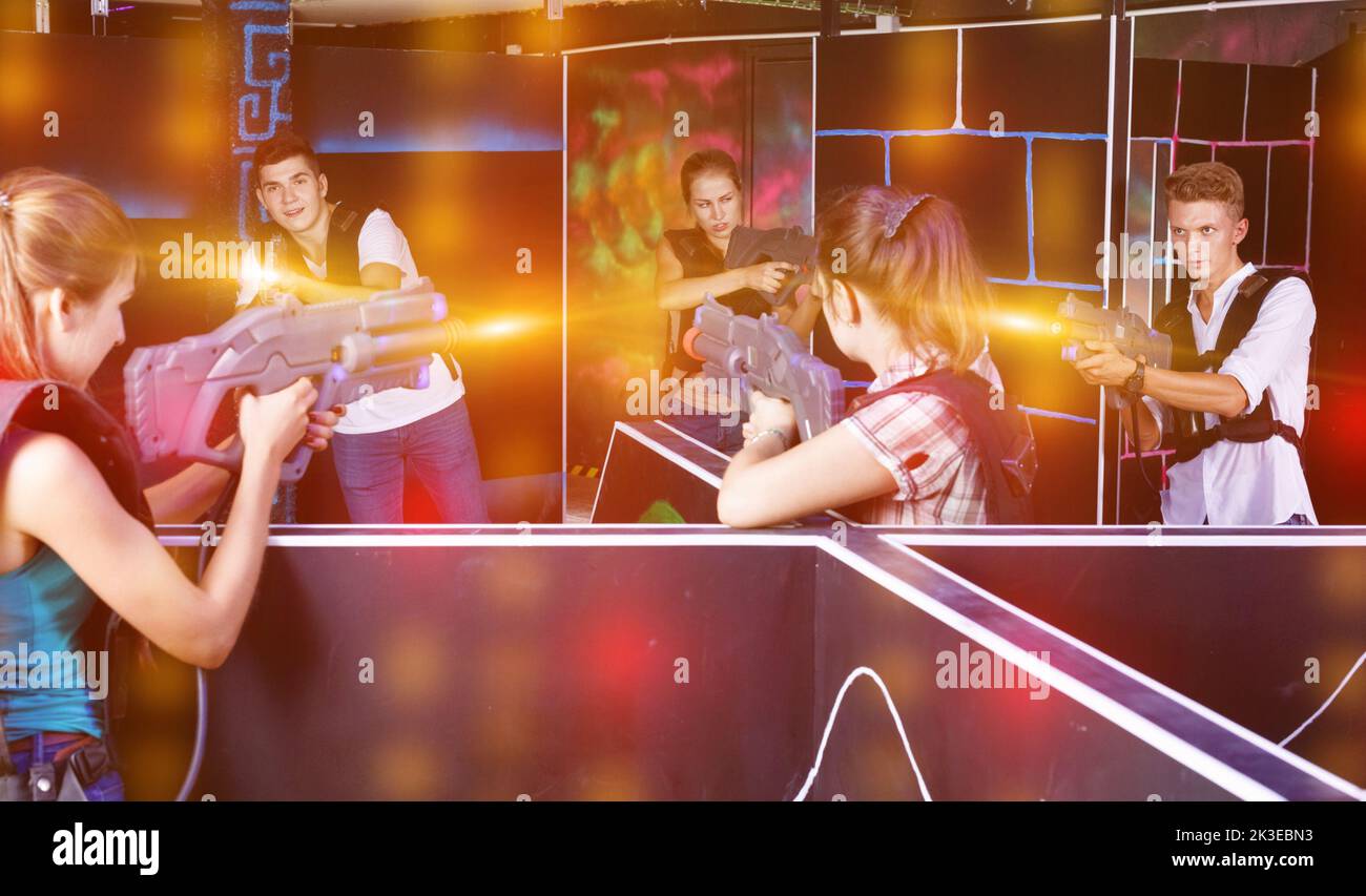 Two laser tag teams playing enthusiastically and aiming at each Stock ...