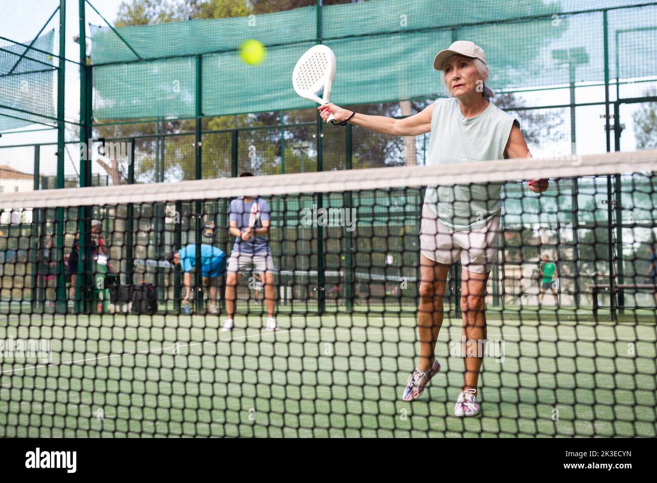 Active elderly woman playing padel tennis on open court Stock Photo - Alamy