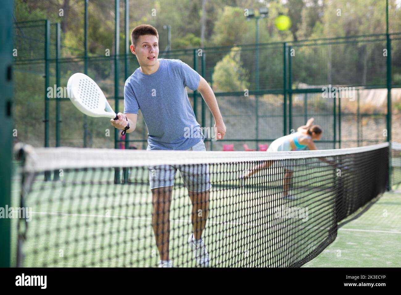 Concentrated man padel player hitting ball with racket Stock Photo - Alamy