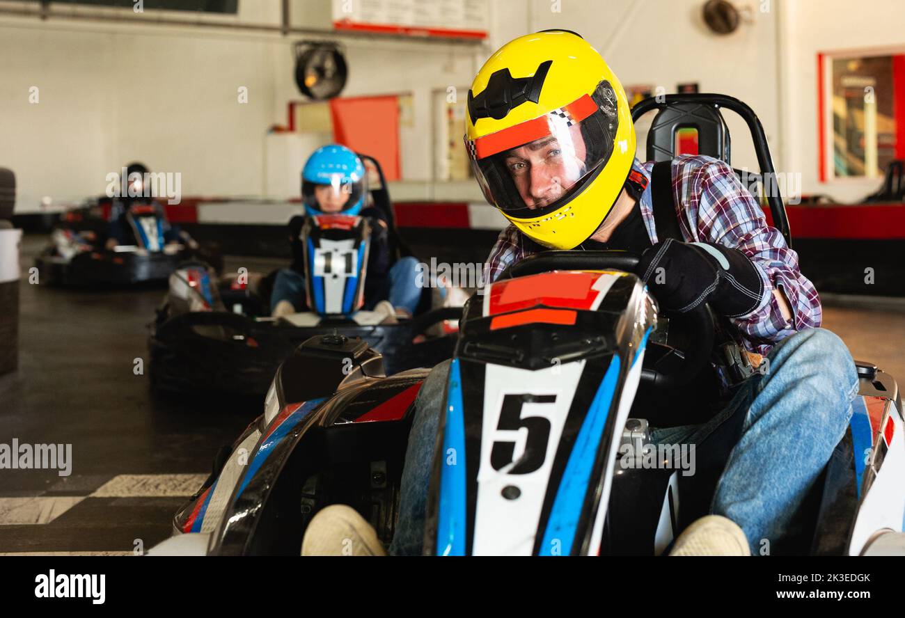 Man and his friends competing on racing cars Stock Photo - Alamy