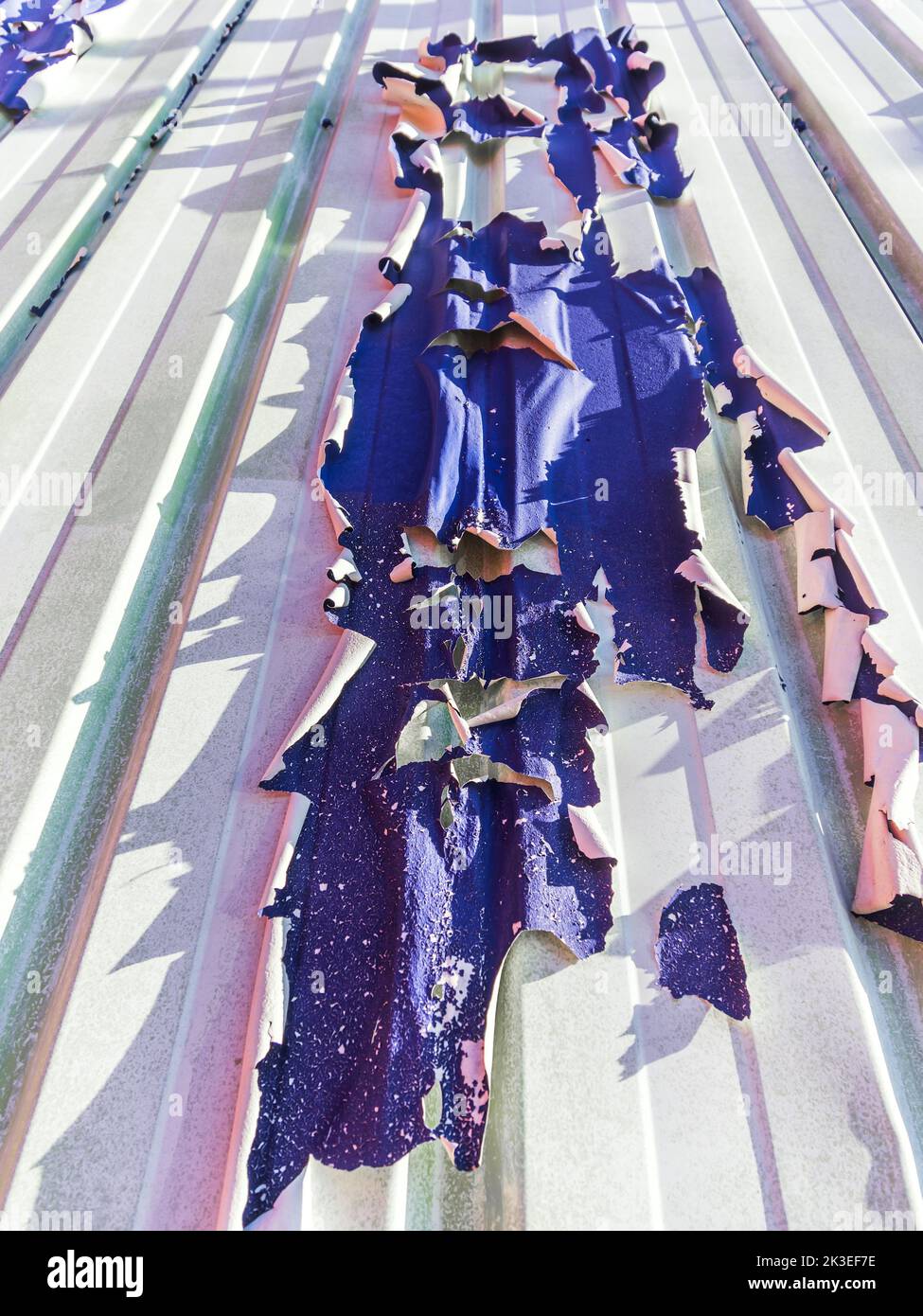 Badly peeling paint on metal cladding of modern building ...