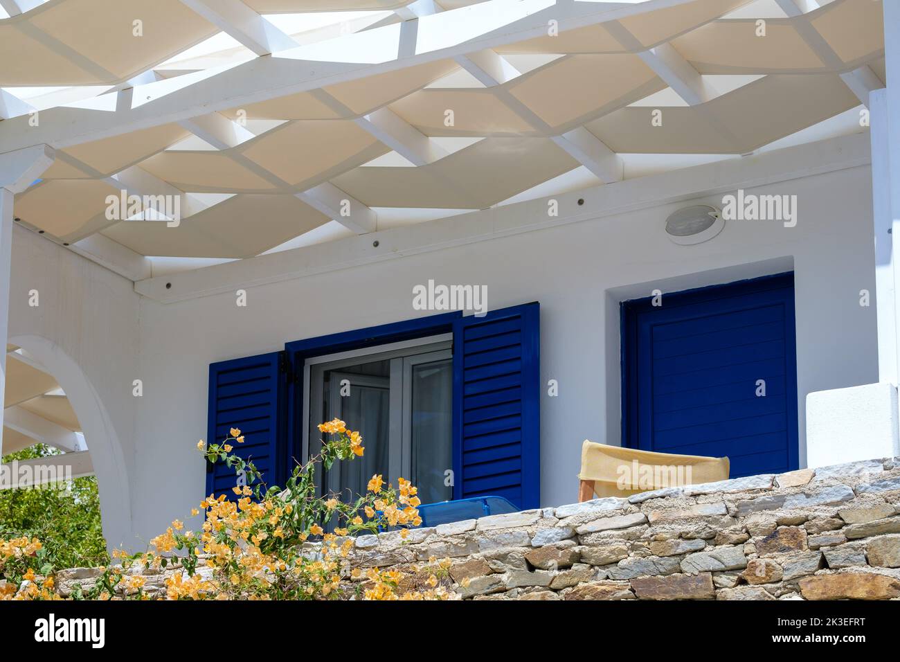 A white washed house with blue window shutters and a balcony in Ios ...