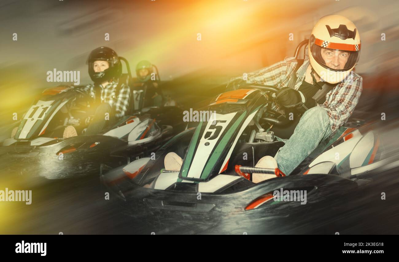 Man and women competing on racing cars Stock Photo - Alamy