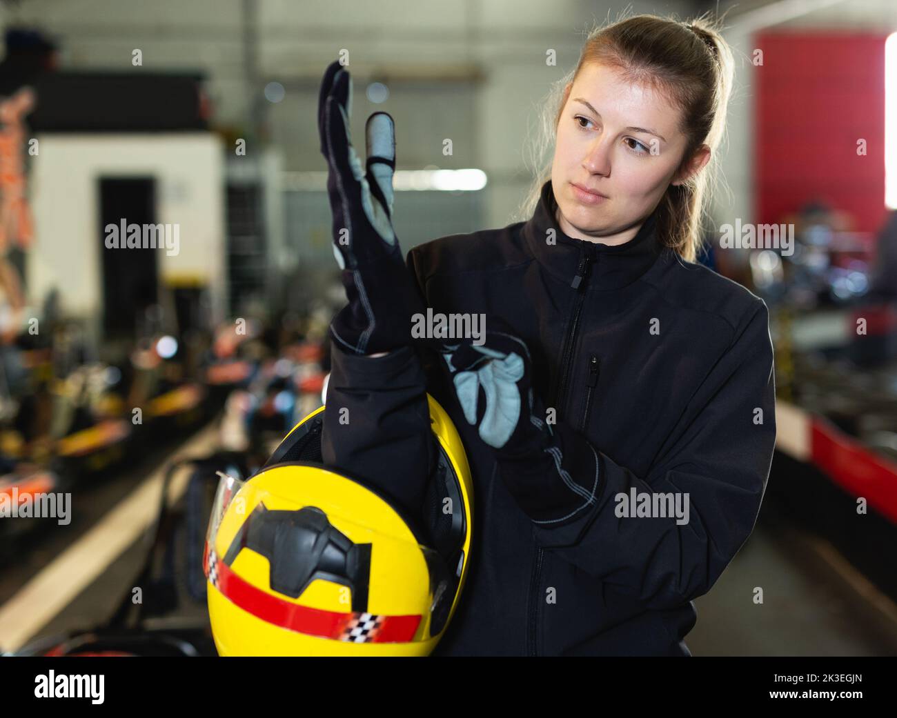 Young woman puts equipment for karting Stock Photo - Alamy