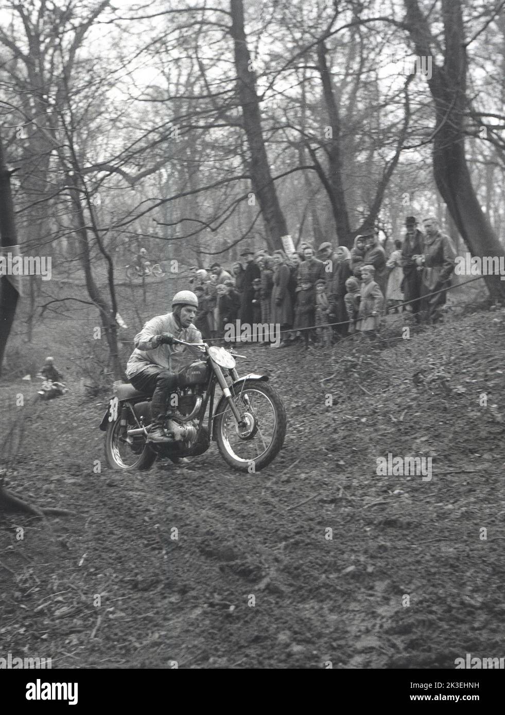 1954, historical, outside on rough terrain in a forest, spectators ...