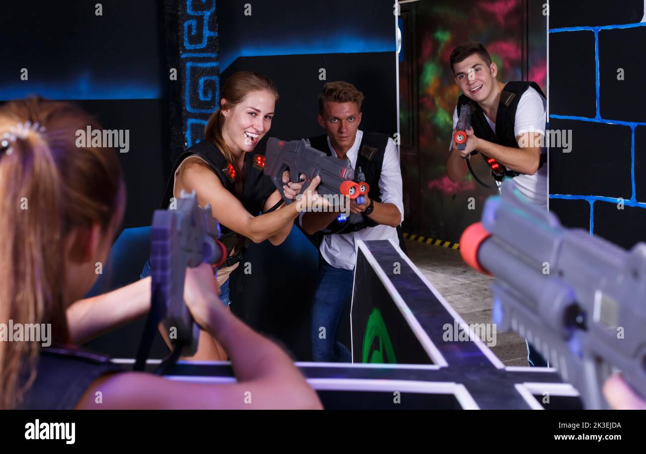 Two teams of laser tag game emotional girls and young men playing Stock ...