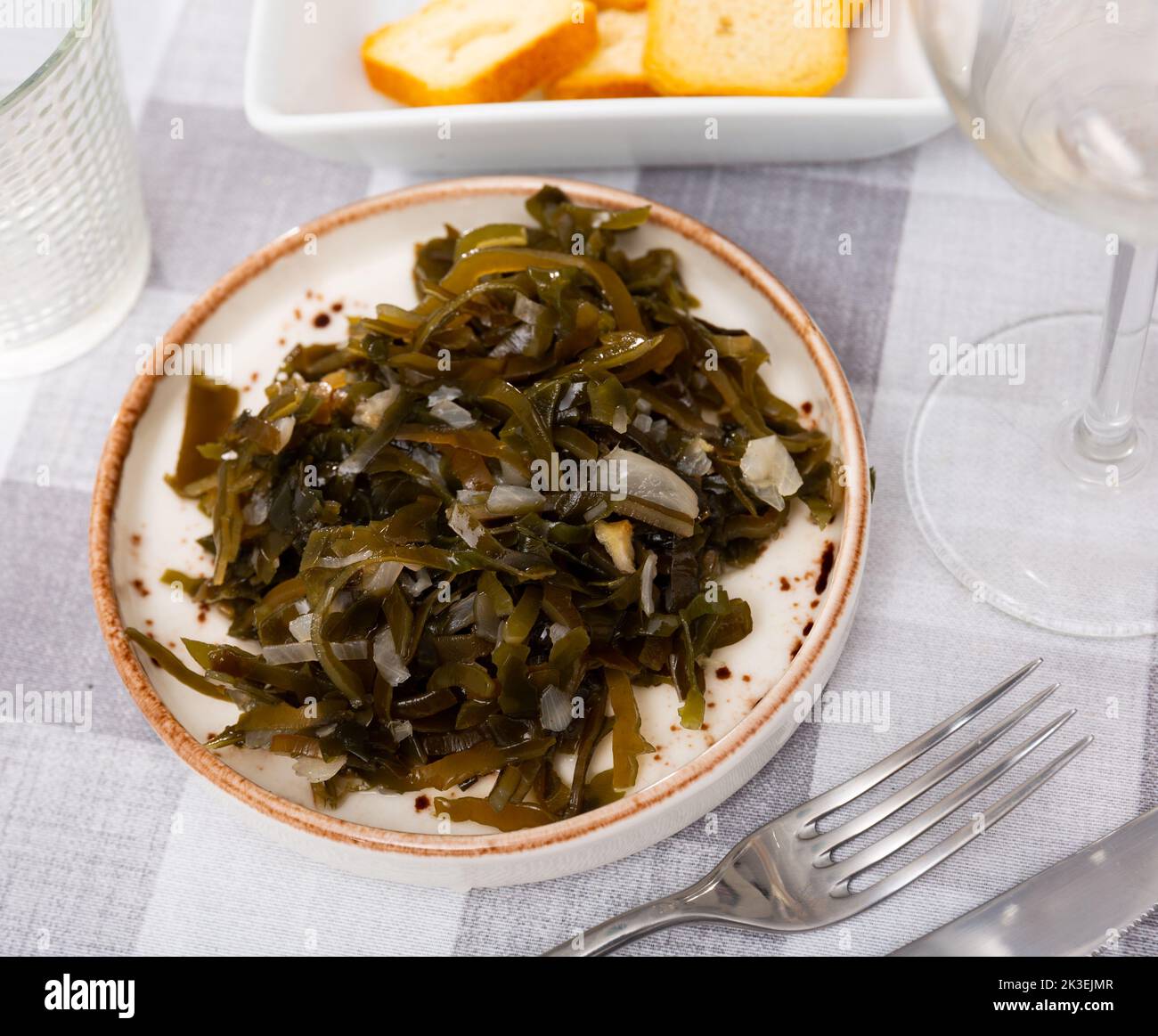 Pickled kelp salad with chopped onions on plate Stock Photo - Alamy