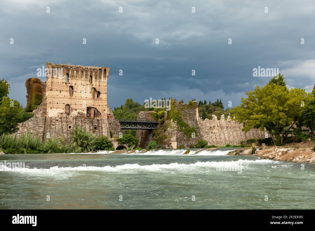Borghetto Scaligeri Castle waterfalls and bridge on a heavy cloudy day ...