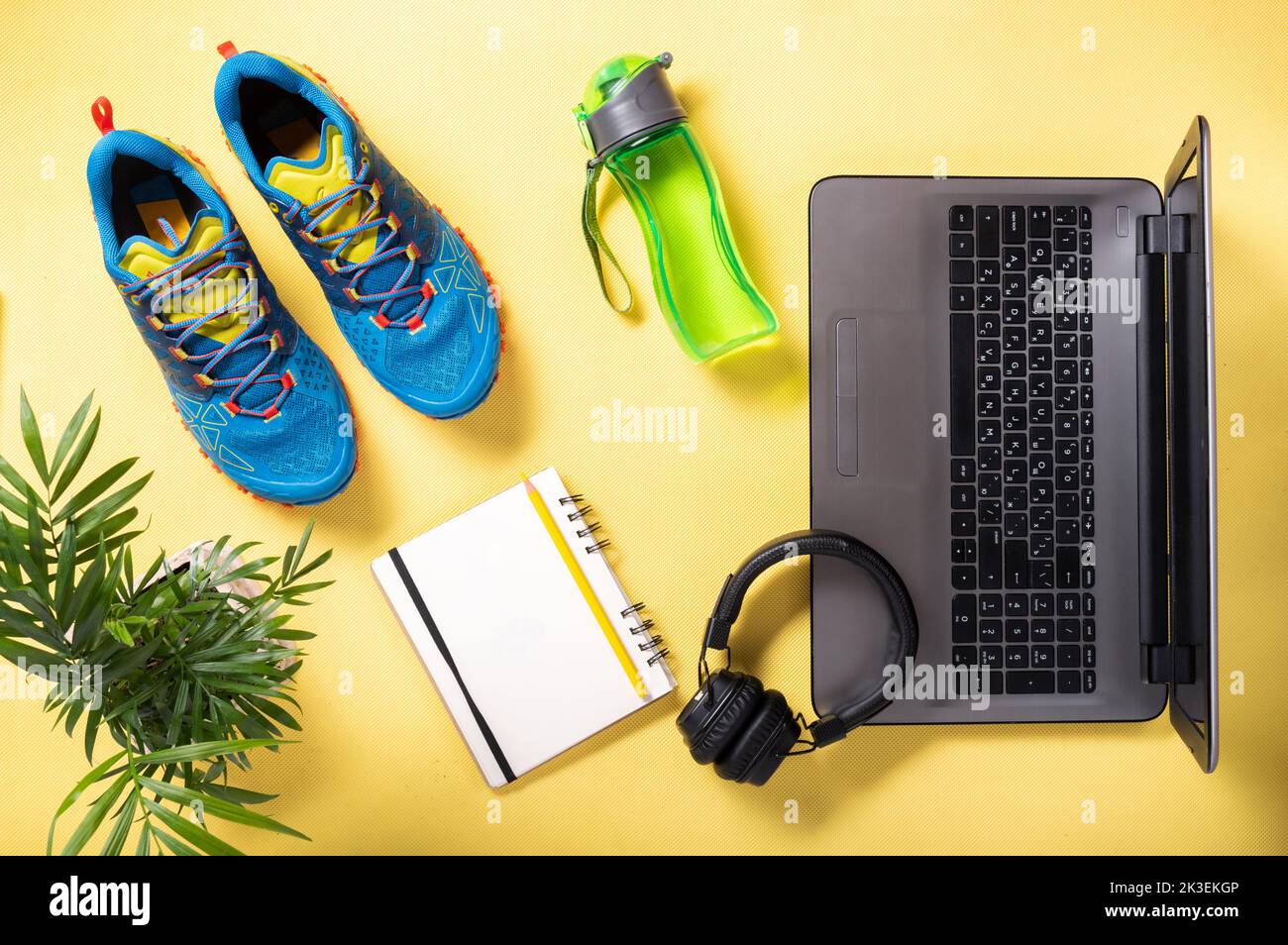 Sports scheduling. Notepad and pencil near the laptop. Running shoes ...