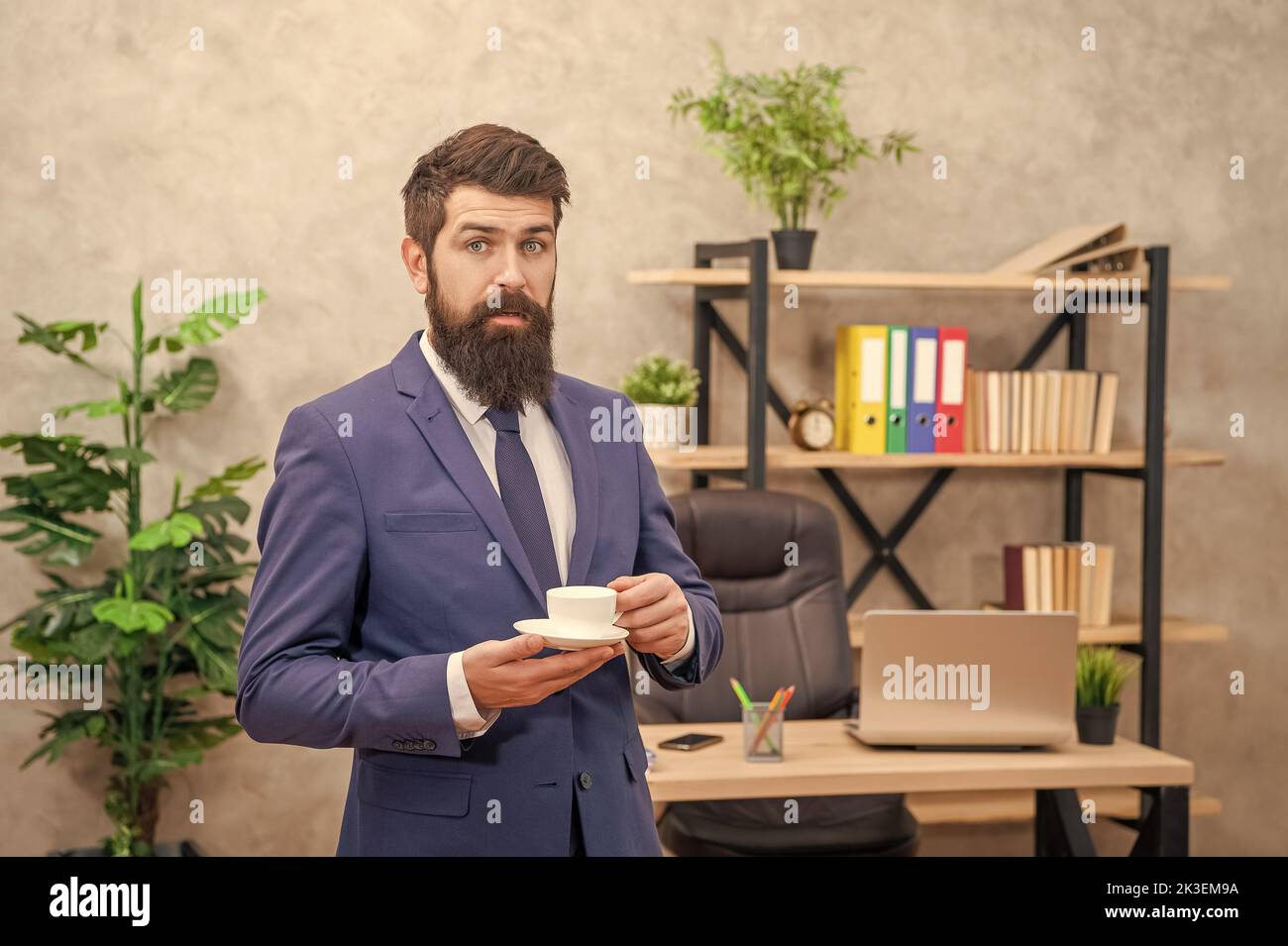 amazed brutal ceo in businesslike suit hold morning coffee cup at the ...